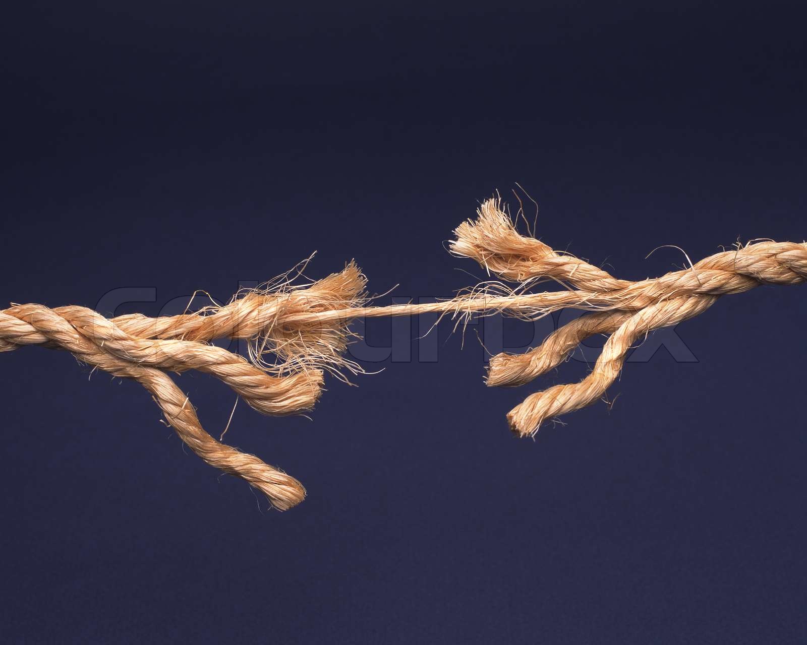 Frayed rope about to break isolated on blue background | Stock image ...