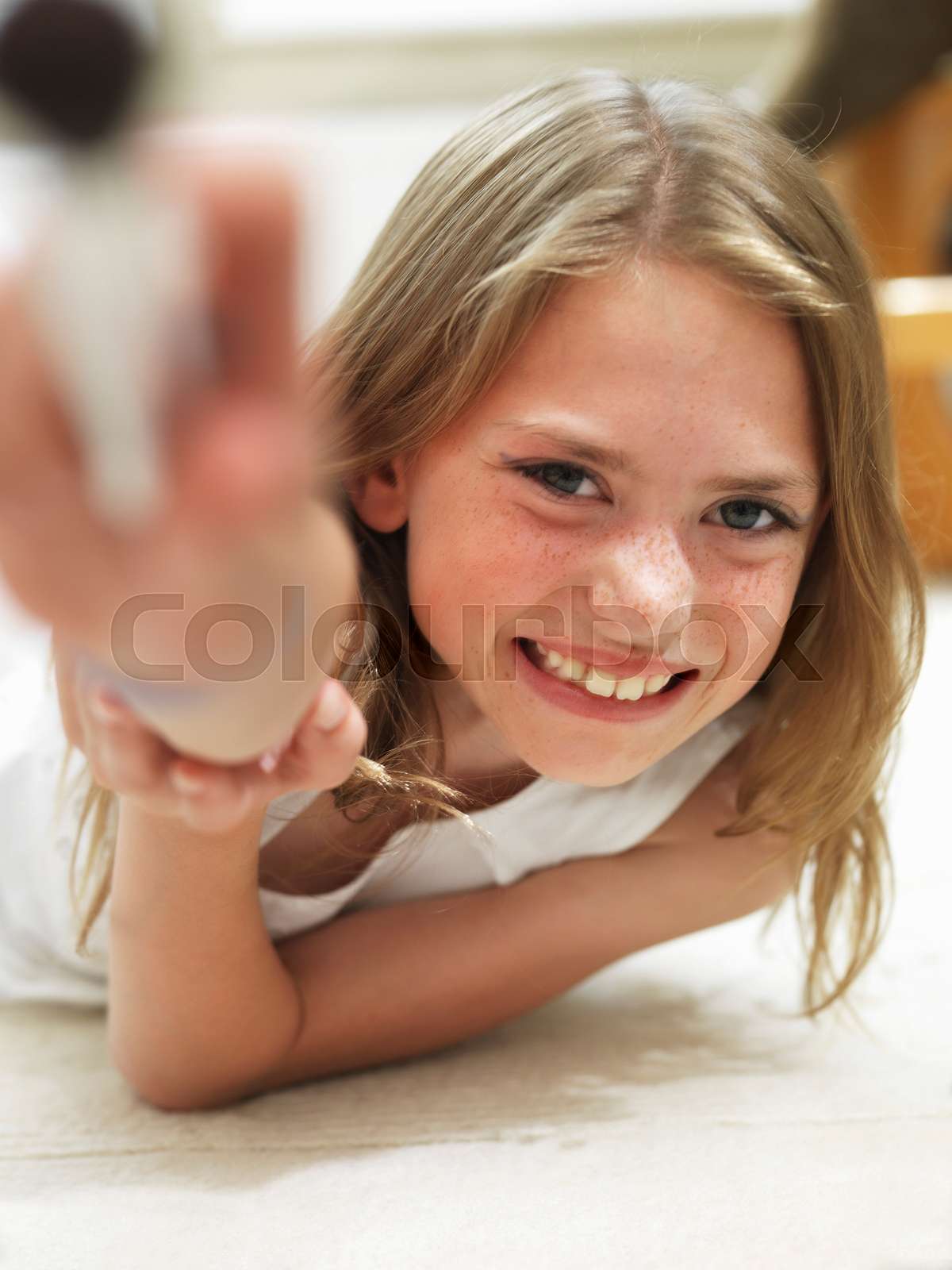 Girl smiling lying on her tummy | Stock image | Colourbox