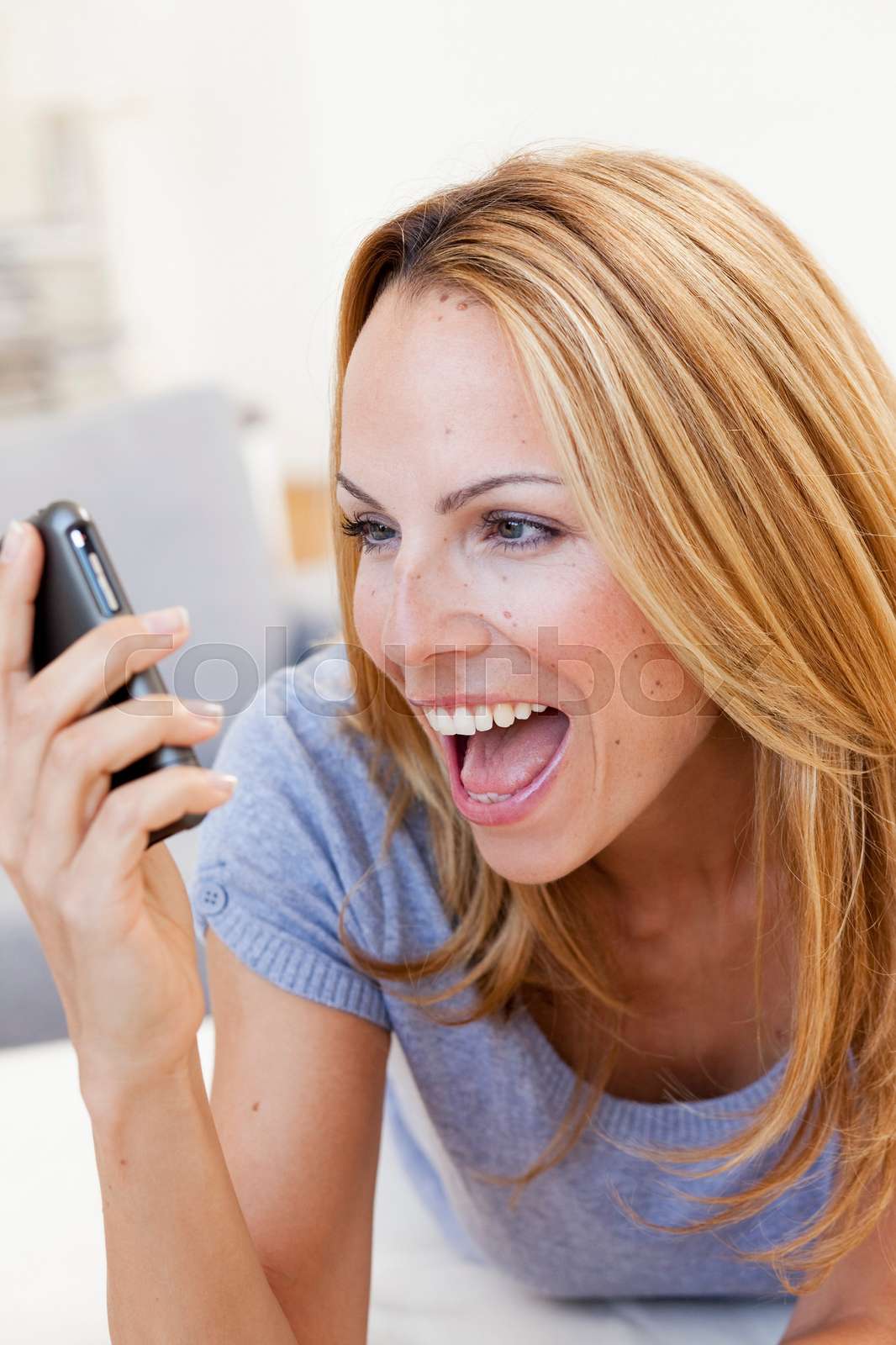 young woman screaming into cell phone | Stock image | Colourbox