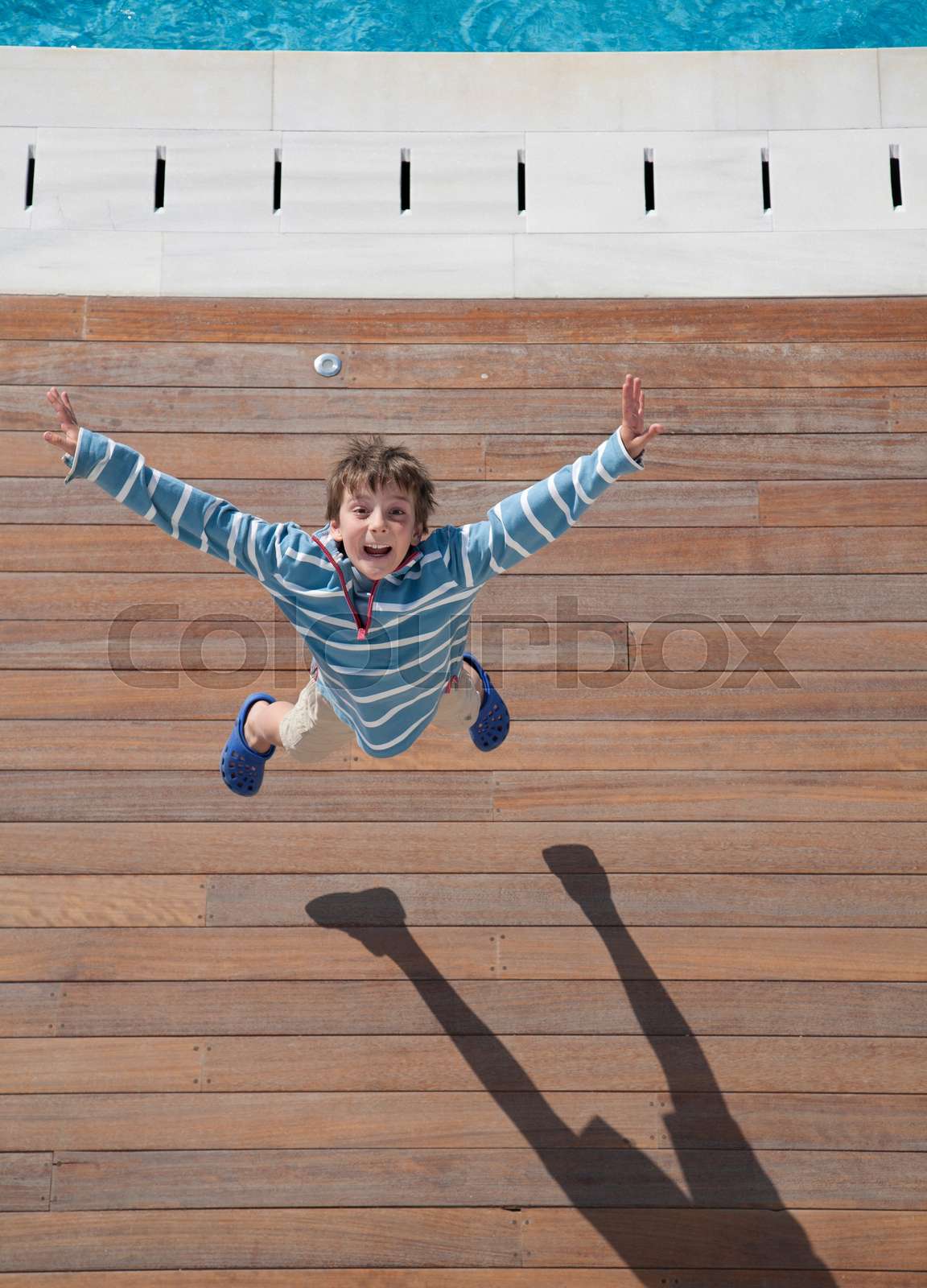 Boy (8-10) leaping into air, aerial view | Stock image | Colourbox