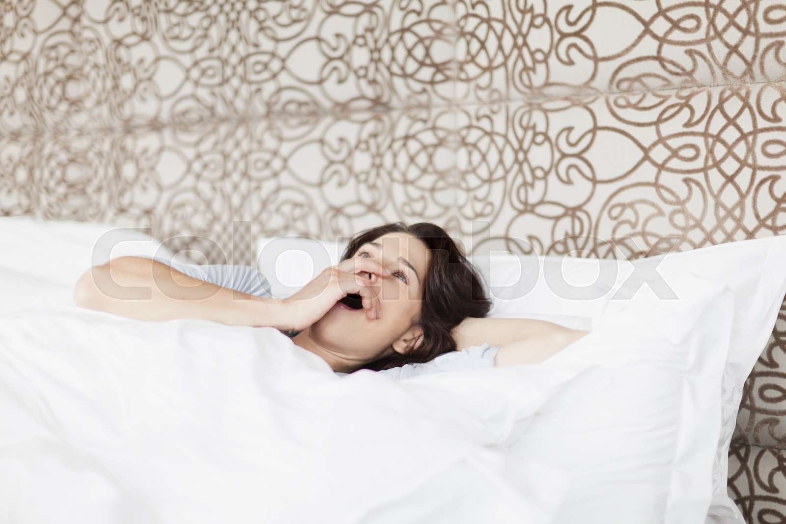 Woman yawning in bed | Stock image | Colourbox