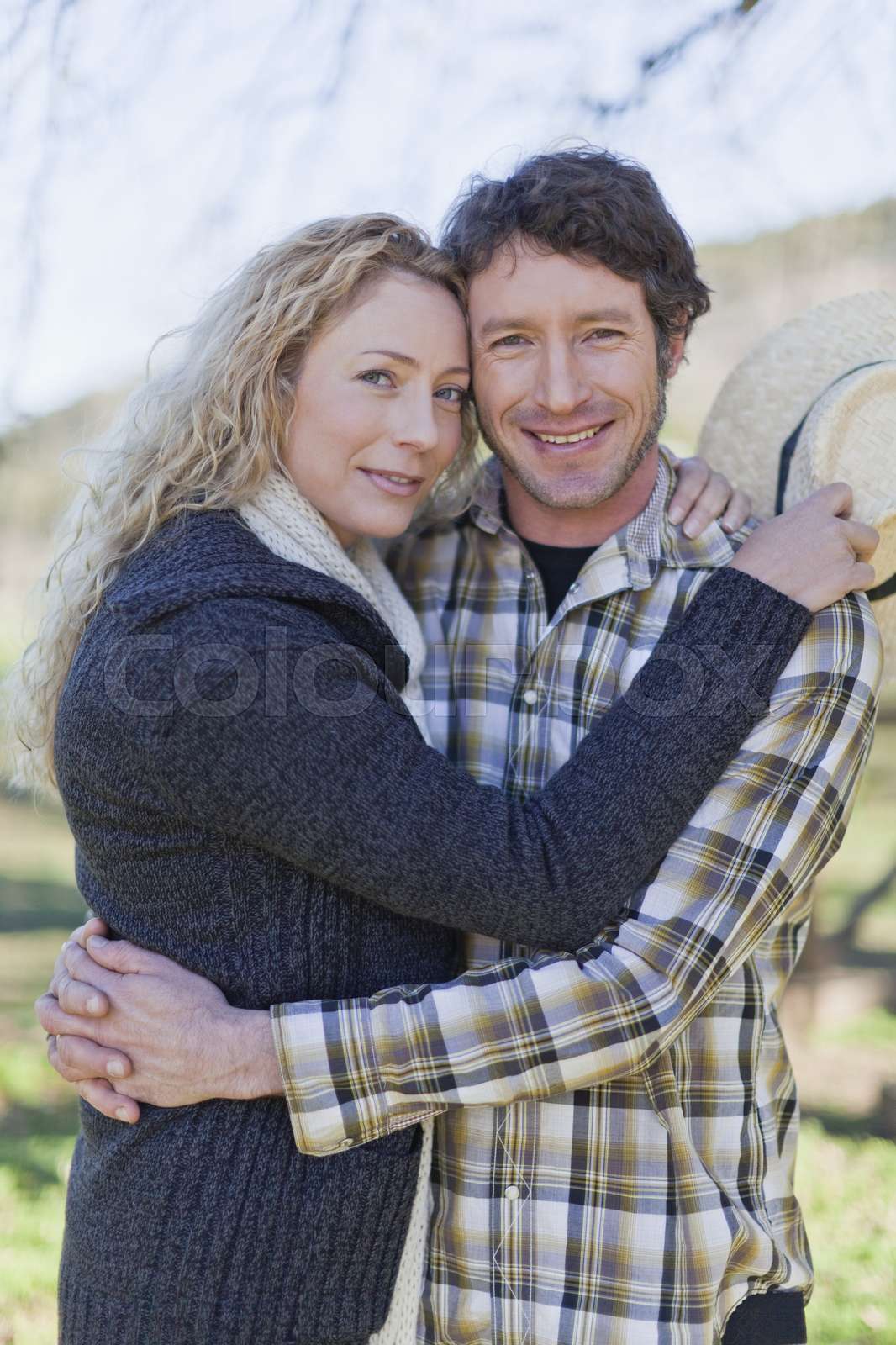 Smiling couple hugging outdoors - Stock Image - Everypixel