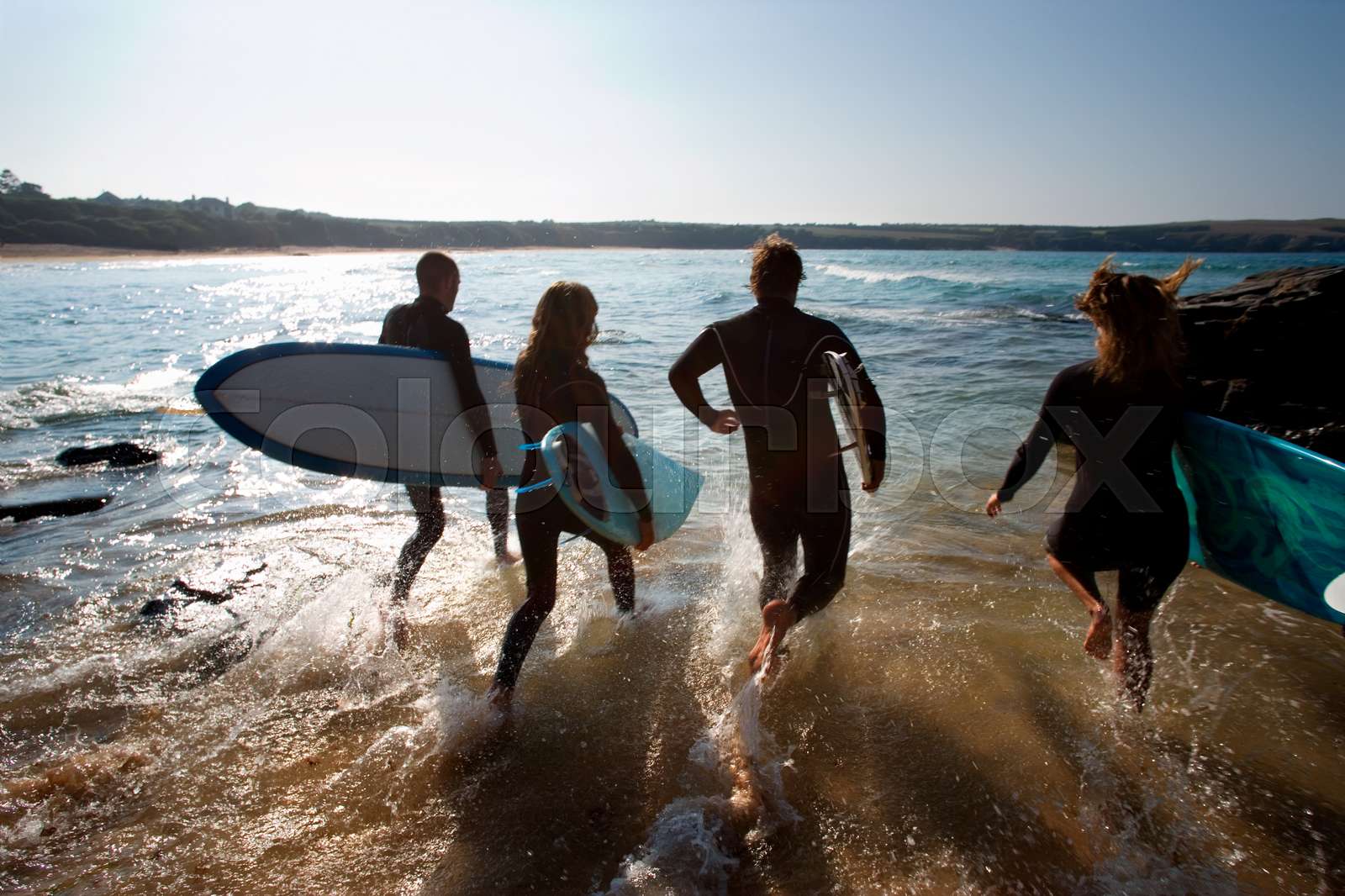 Four people running into the water | Stock image | Colourbox