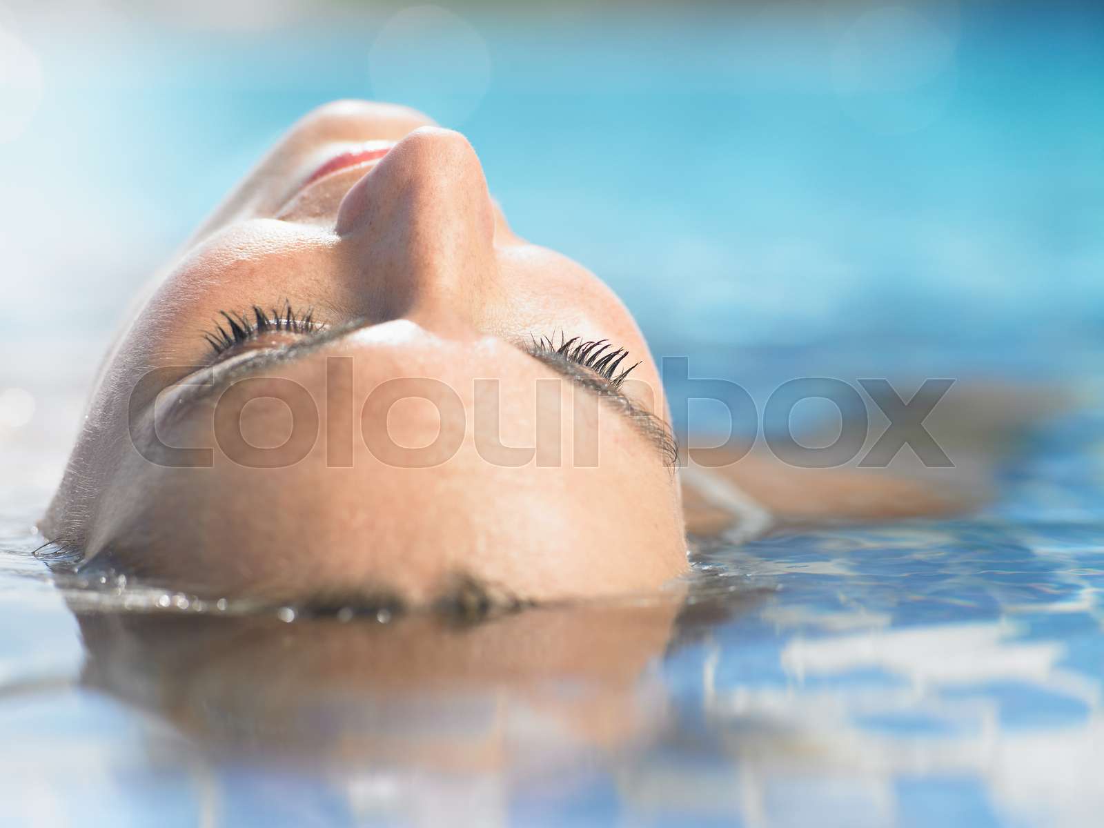 A woman floating in hotel pool | Stock image | Colourbox
