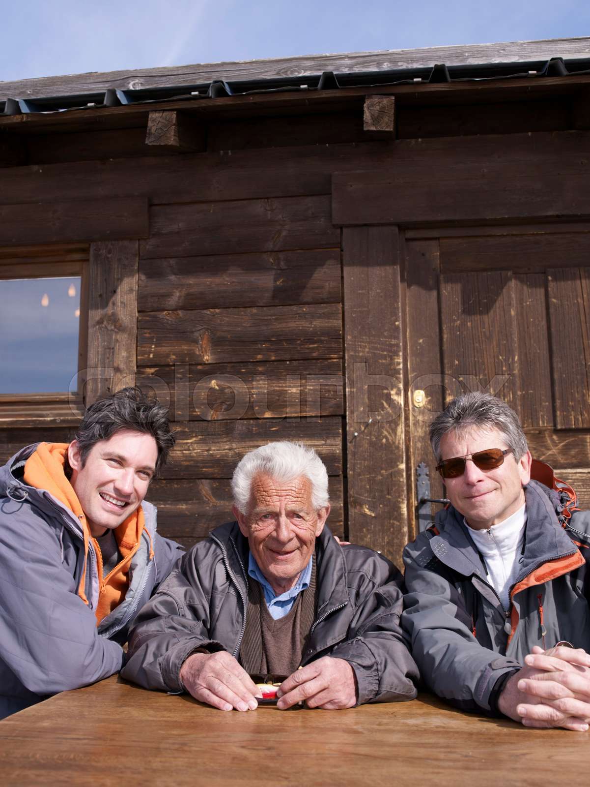 3 men sitting at table smiling | Stock image | Colourbox