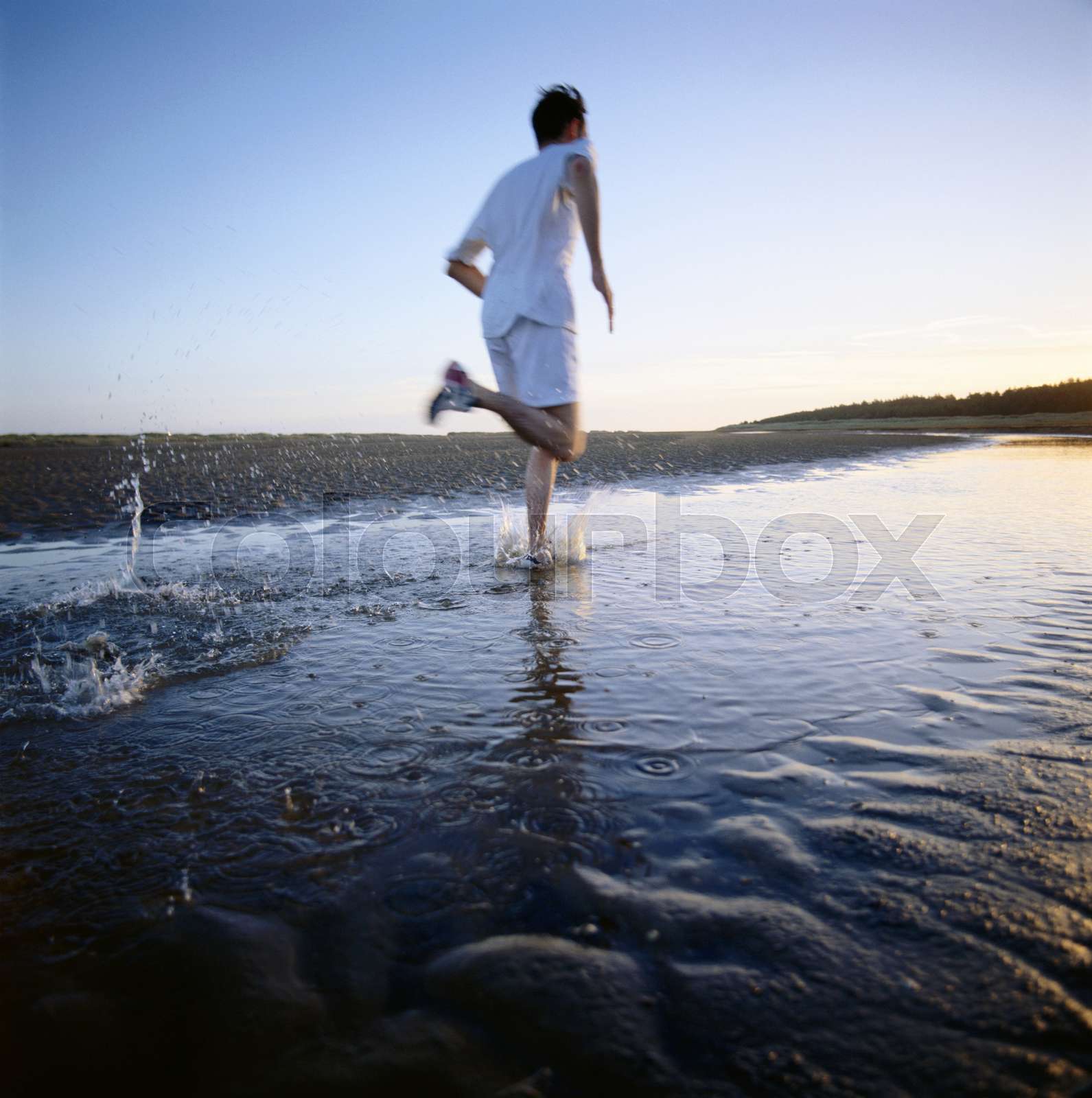 Man running in water on beach | Stock image | Colourbox