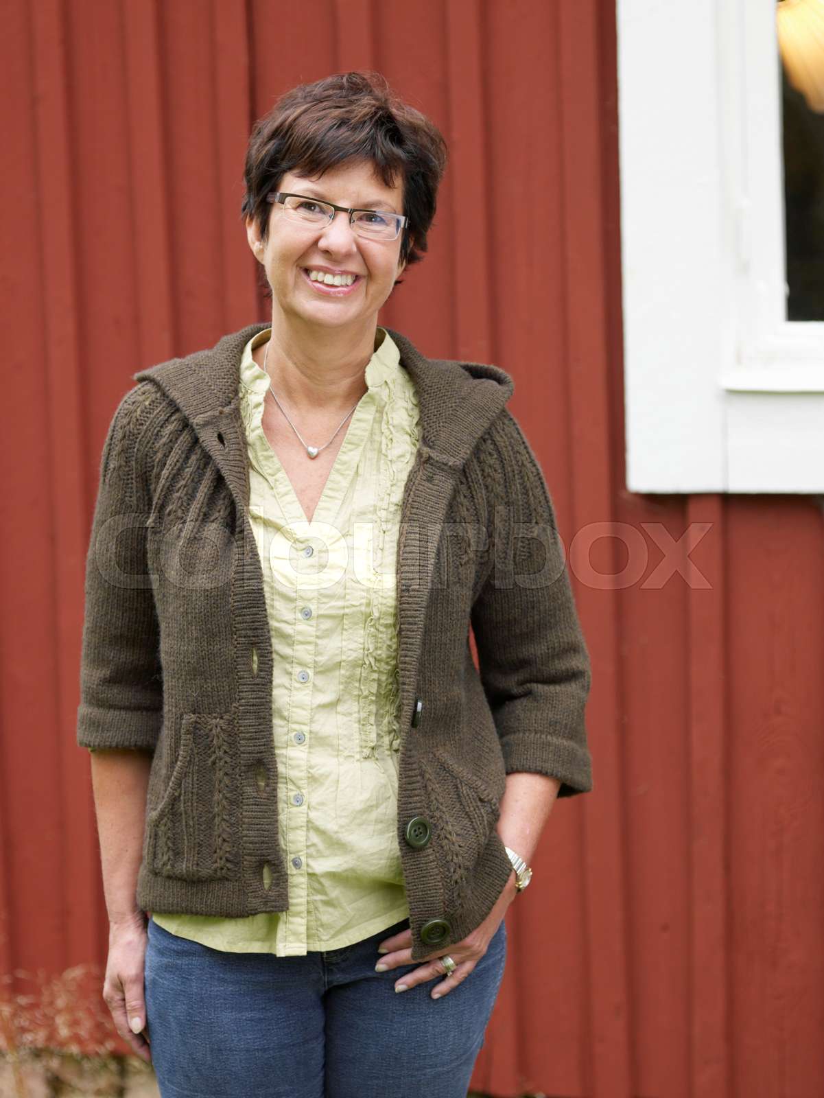 Middle aged woman by country cottage | Stock image | Colourbox