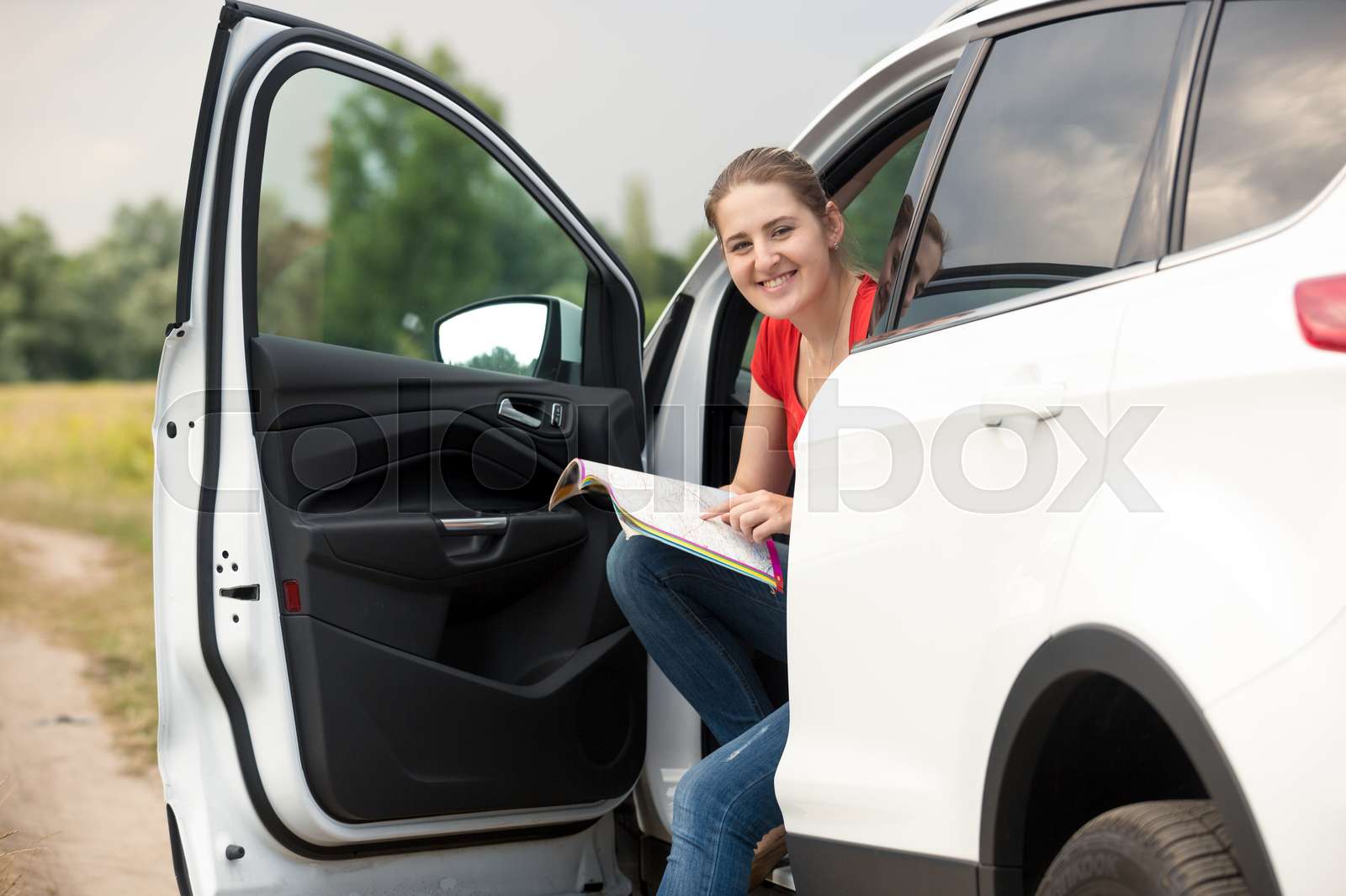 Young woman got lost while driving in countryside and reading map to ...