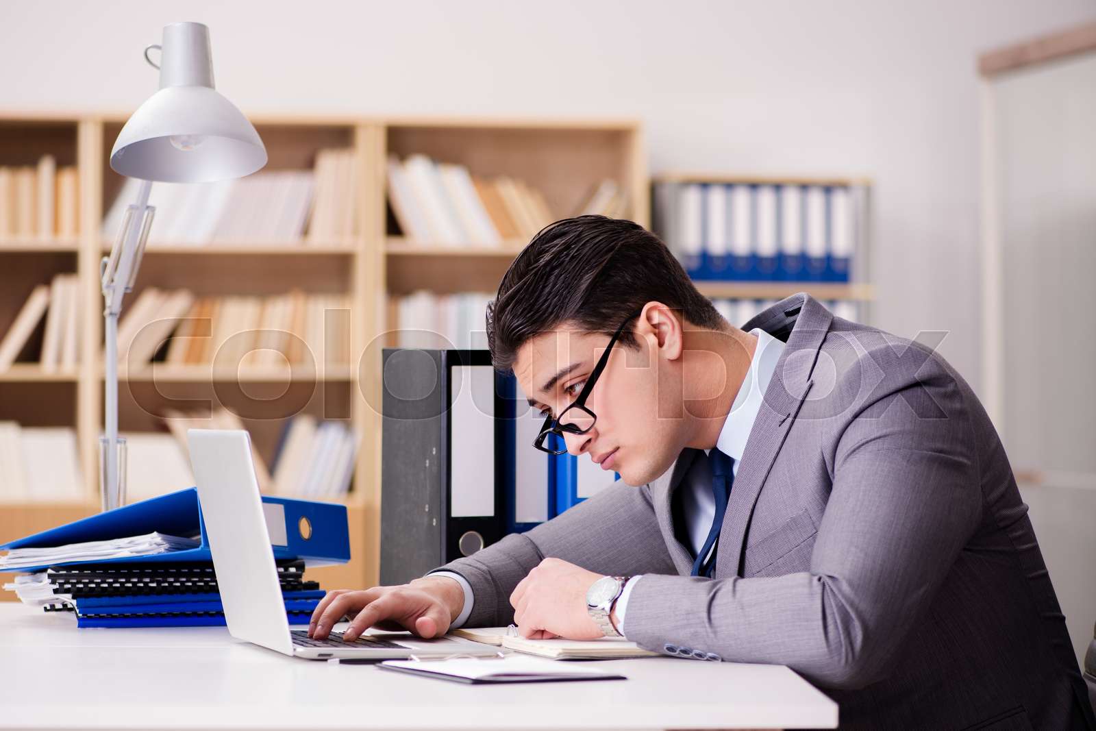 Tired businessman working in the office | Stock image | Colourbox