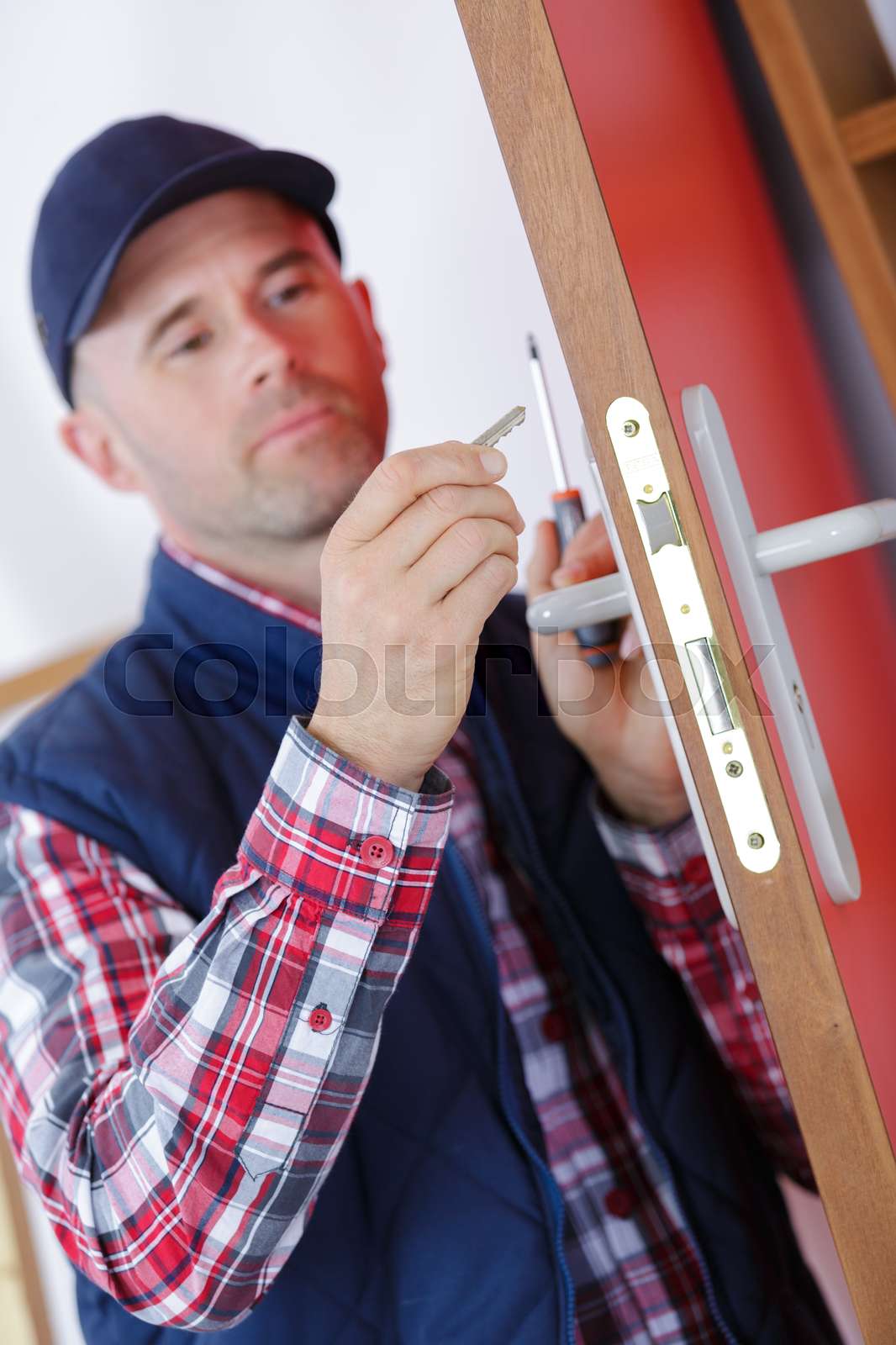 man fixing the door with screwdriver | Stock image | Colourbox