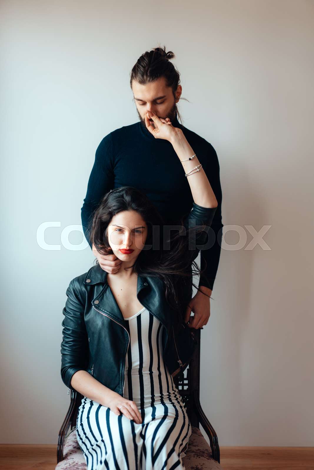 Girl sitting on a chair guy standing behind her | Stock image | Colourbox