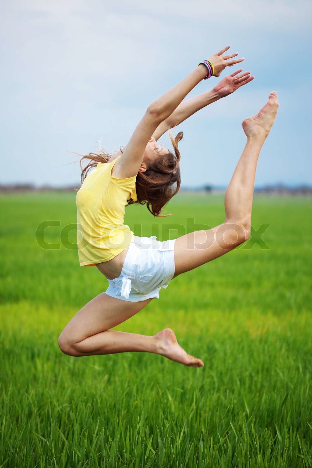 Young beautiful girl doing gymnastic jumps outdoors | Stock image ...