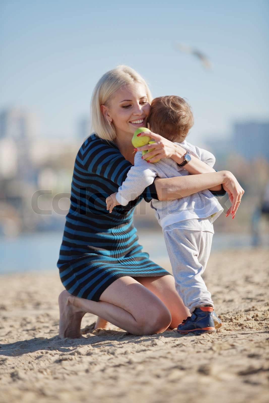 Ung mor med sit barn hviler på stranden | Stock foto | Colourbox