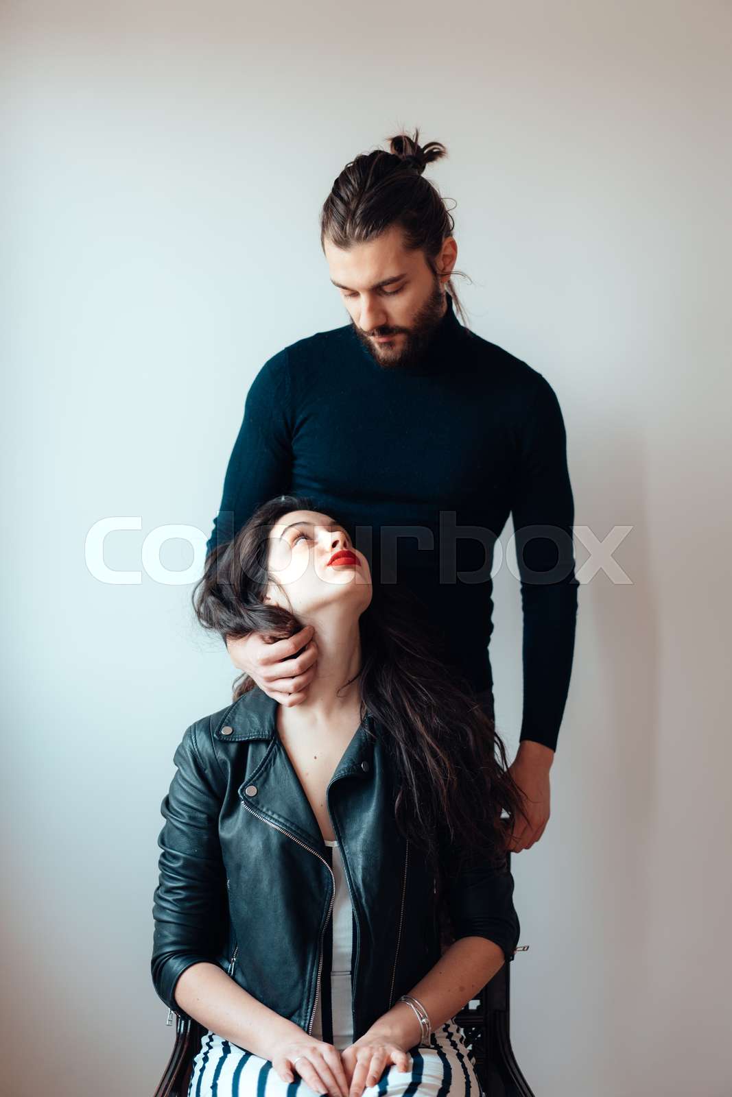 Girl sitting on a chair guy standing behind her | Stock image | Colourbox