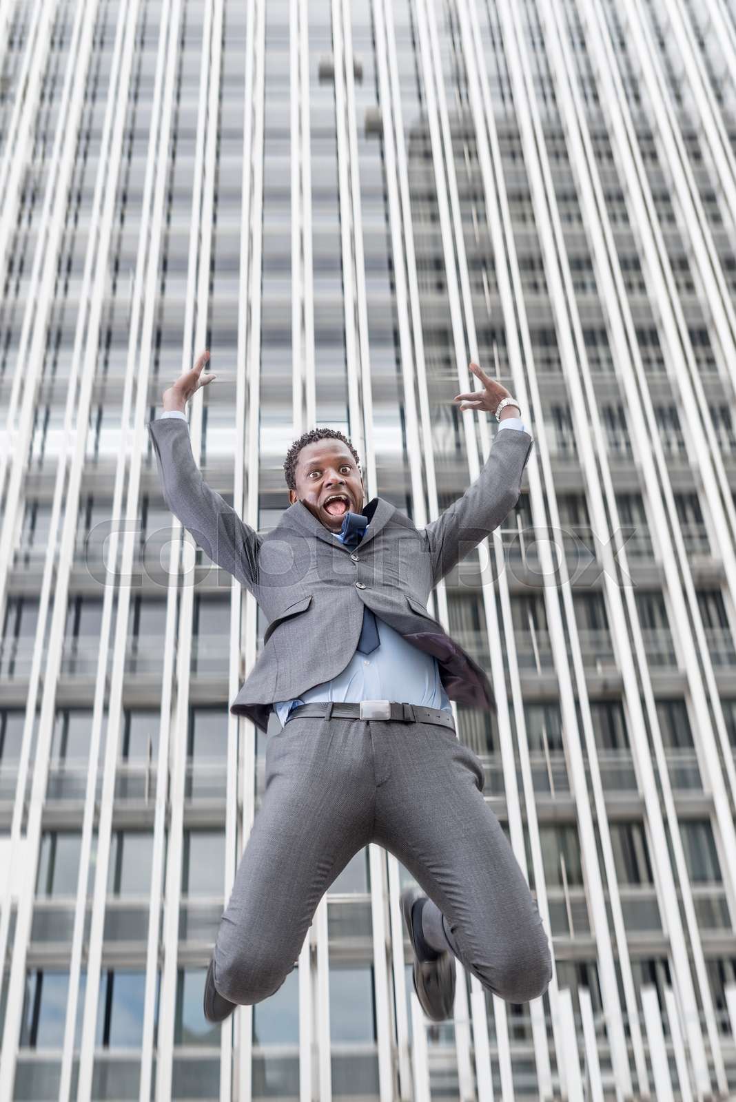 Businessman falling from a skyscraper over a city | Stock image | Colourbox