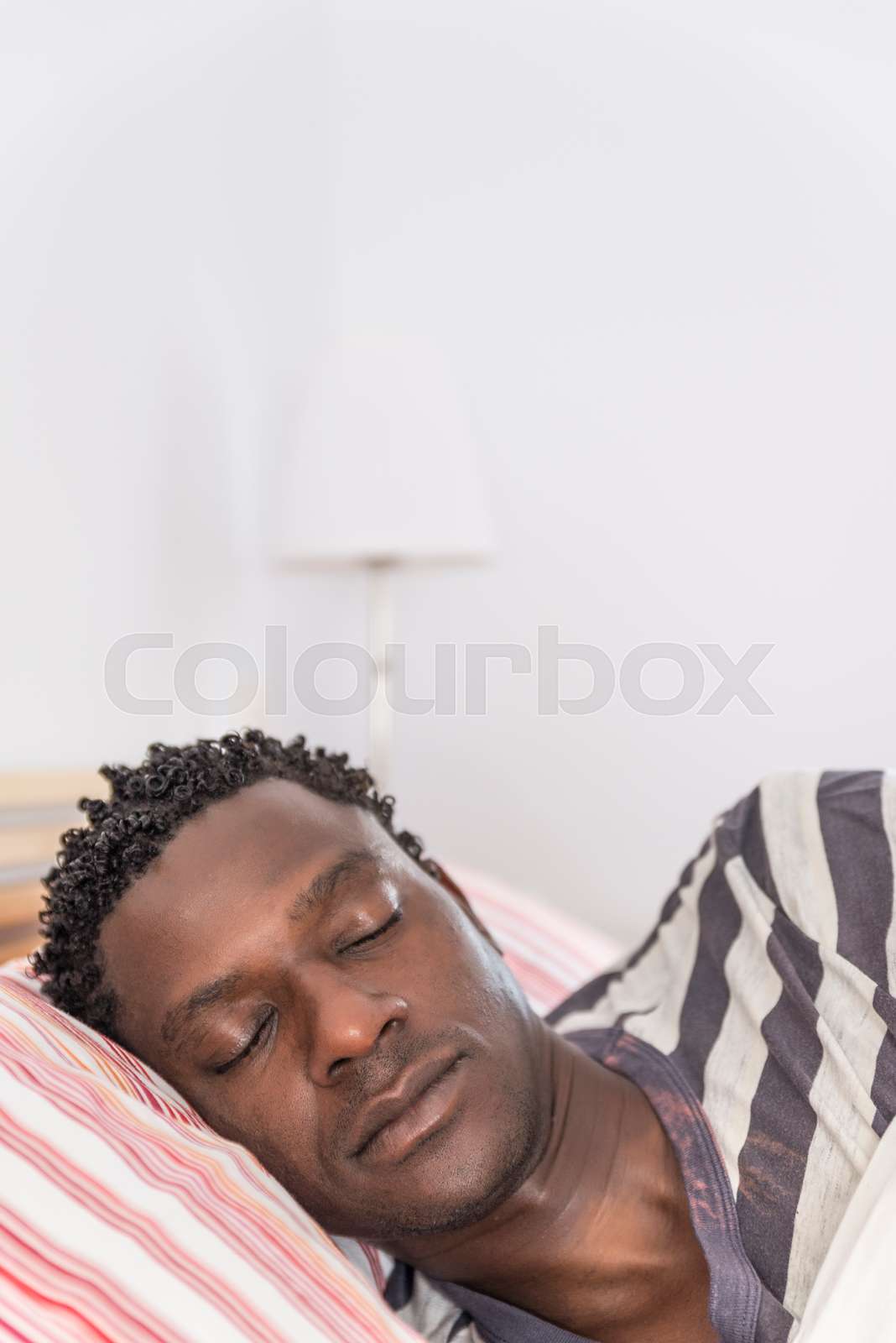 Peaceful african black man sleeping in bed | Stock image | Colourbox