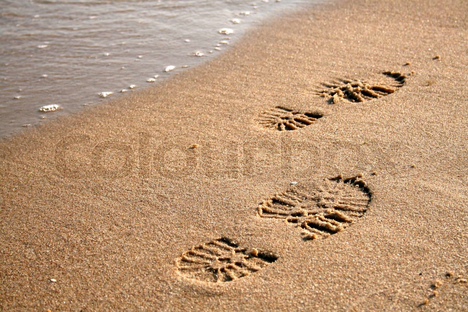 Fodspor i sandet tæt på bølgerne | Stock foto | Colourbox