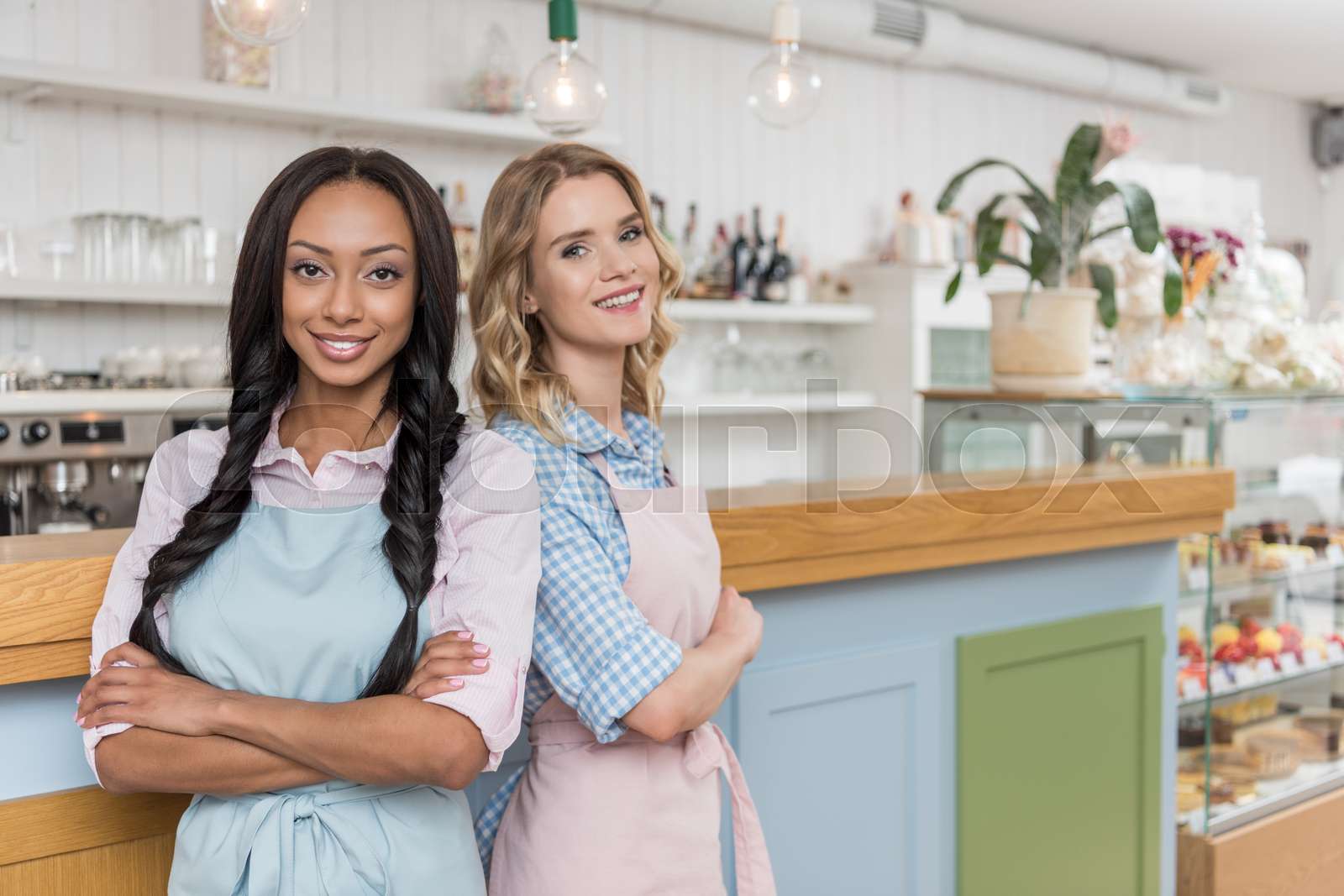 young attractive multiethnic waitresses looking at camera while ...