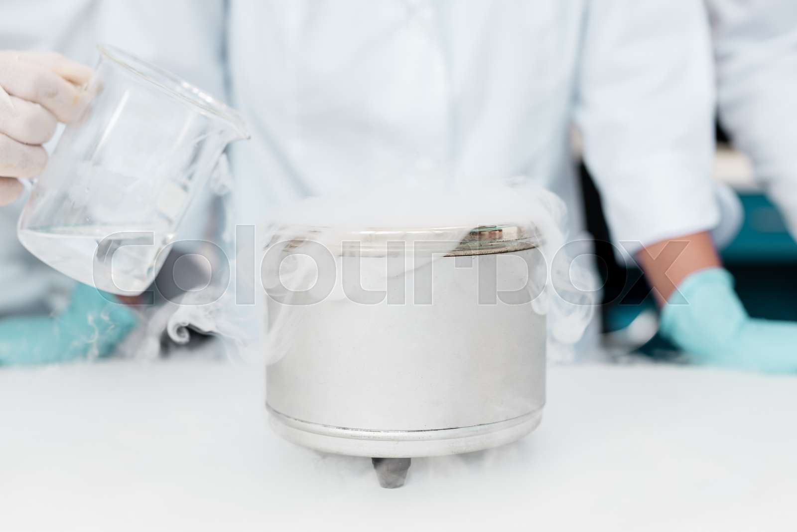 Close-up partial view of scientist making experiment with dry ice in ...