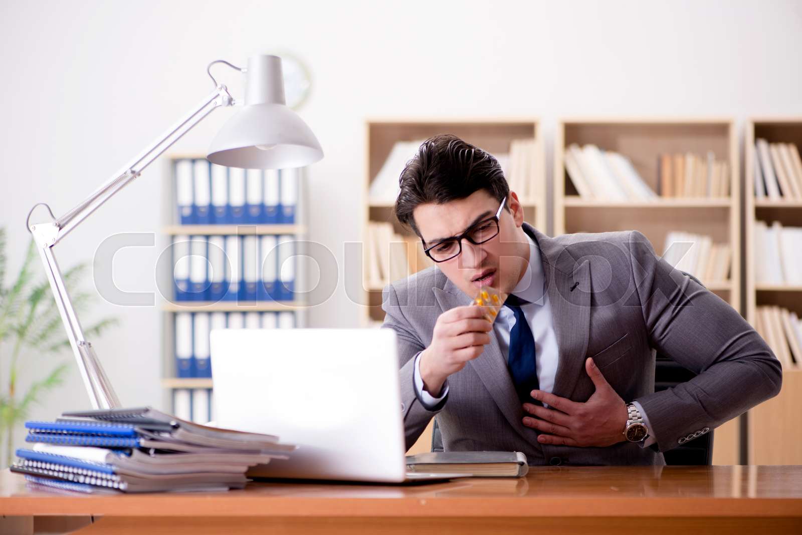 Businessman feeling pain in the office | Stock image | Colourbox
