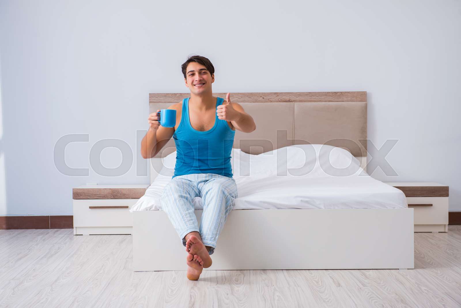 Young man waking up in bed | Stock image | Colourbox