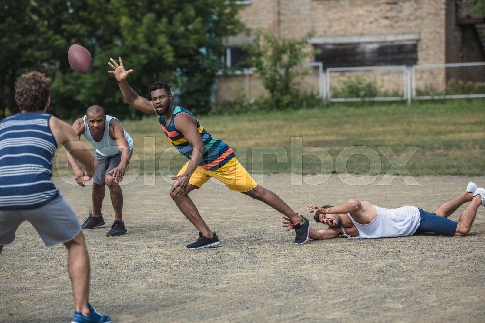 group of young multicultural men playing football on court | Stock ...