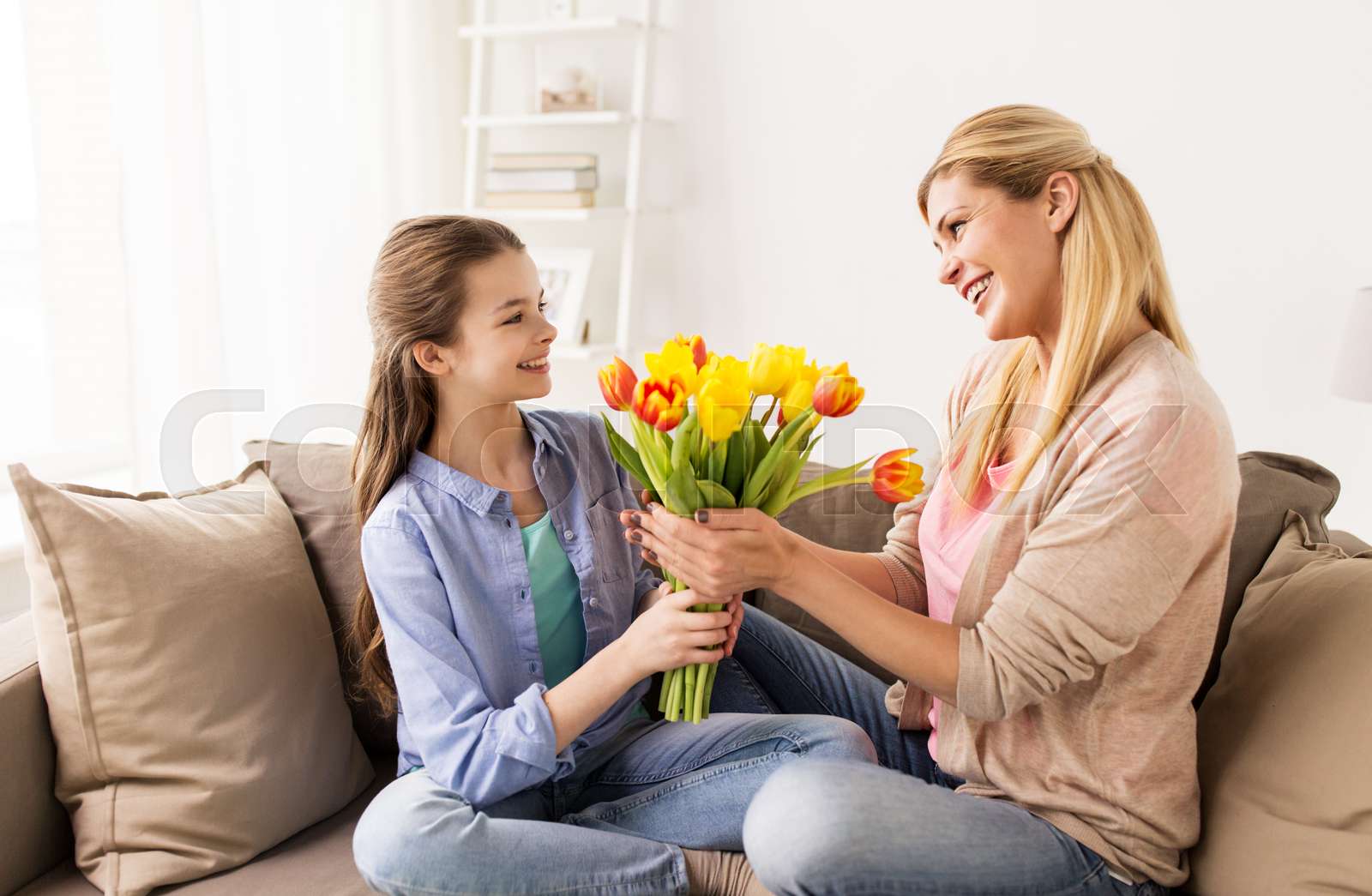 happy girl giving flowers to mother at home | Stock image | Colourbox