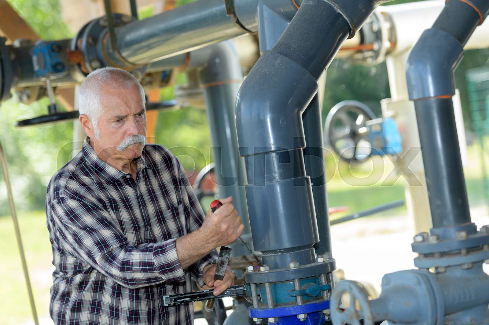 old man working at a water pvc pipe section | Stock image | Colourbox