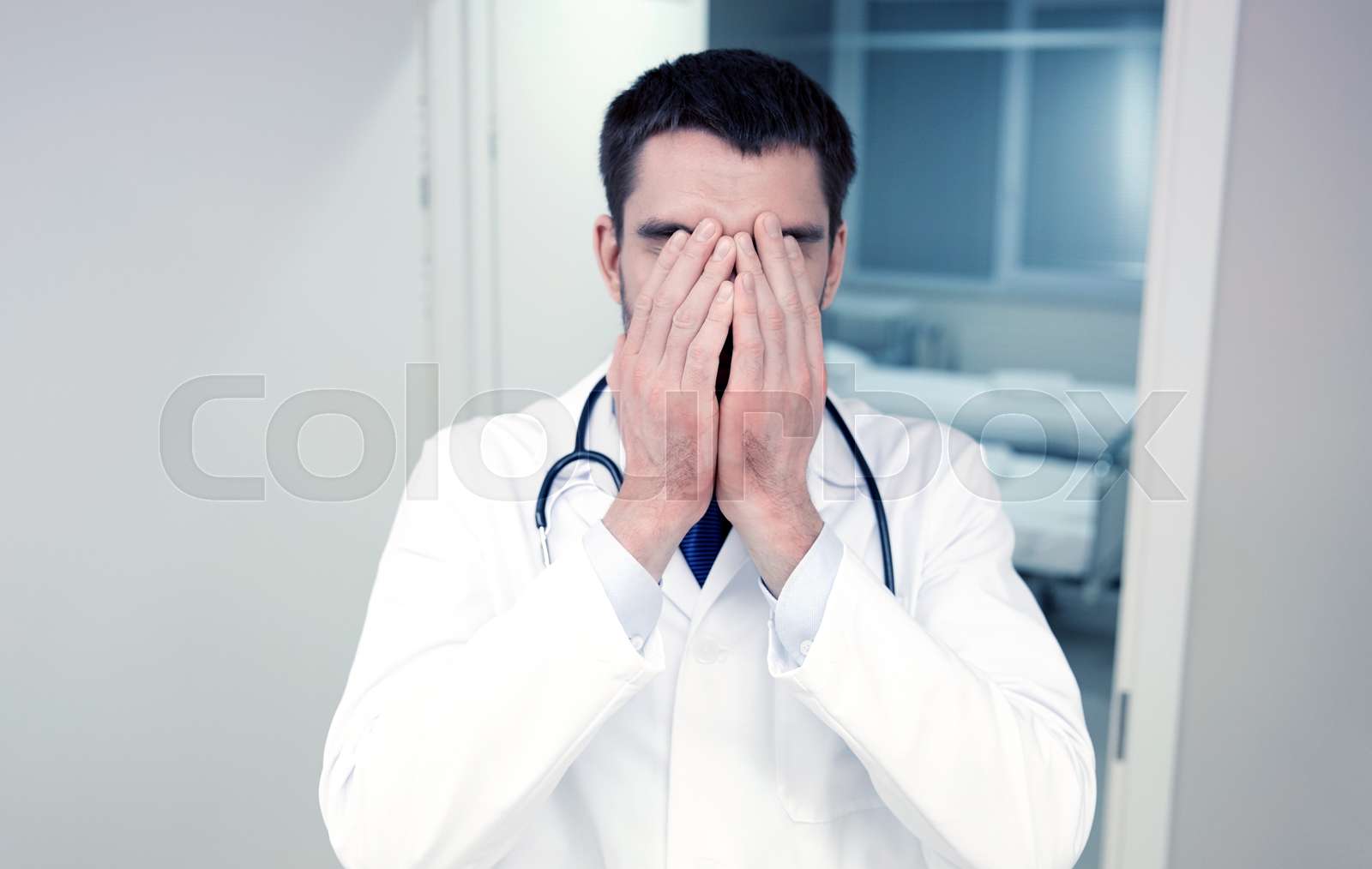 sad or crying male doctor at hospital ward | Stock image | Colourbox