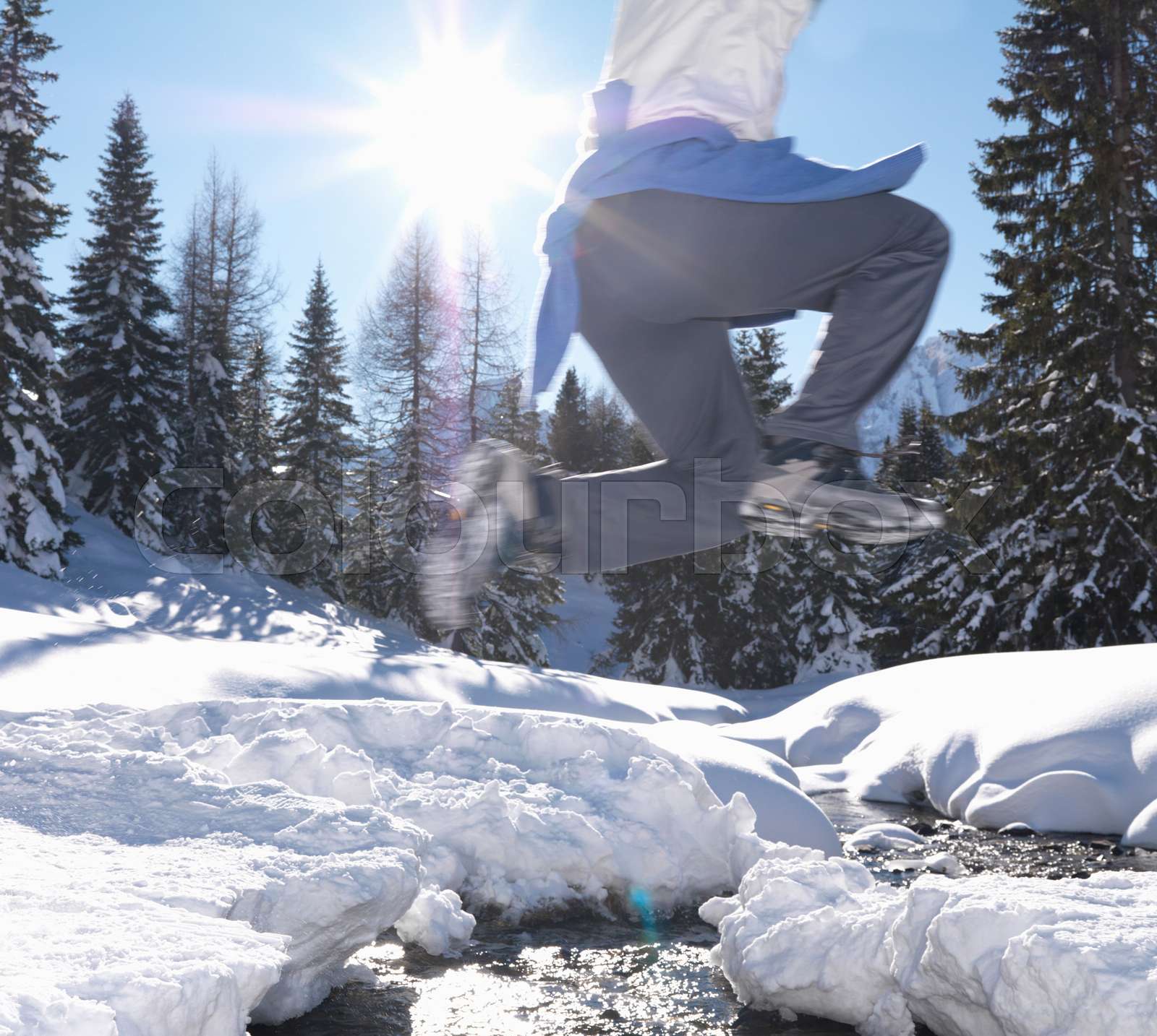 Man jumping across stream | Stock image | Colourbox