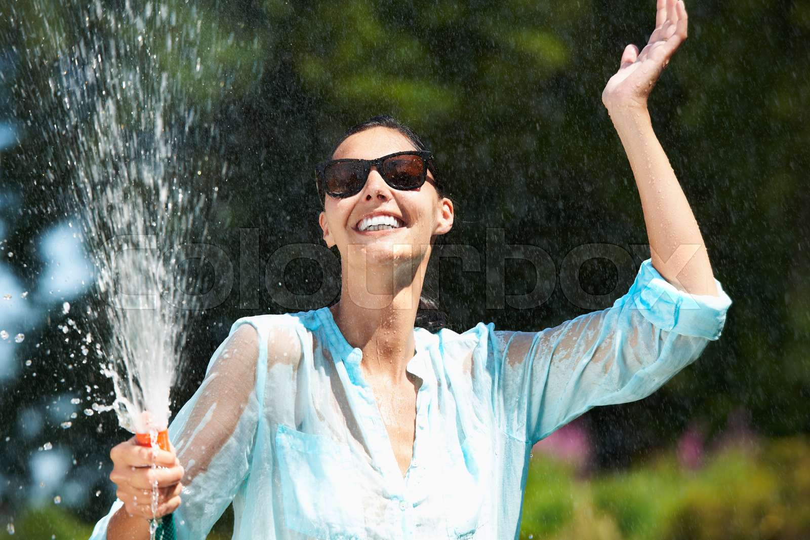 Woman watering the garden, and herself | Stock image | Colourbox
