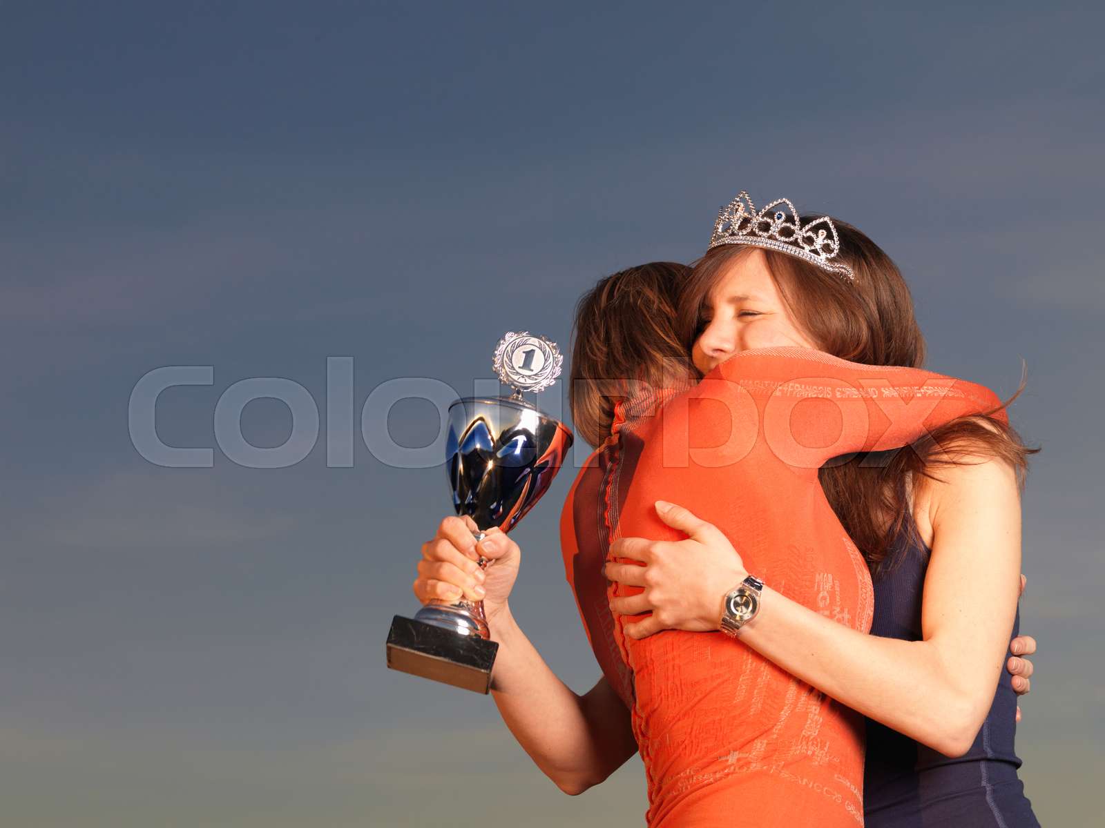 Woman hugging woman, holding trophy | Stock image | Colourbox