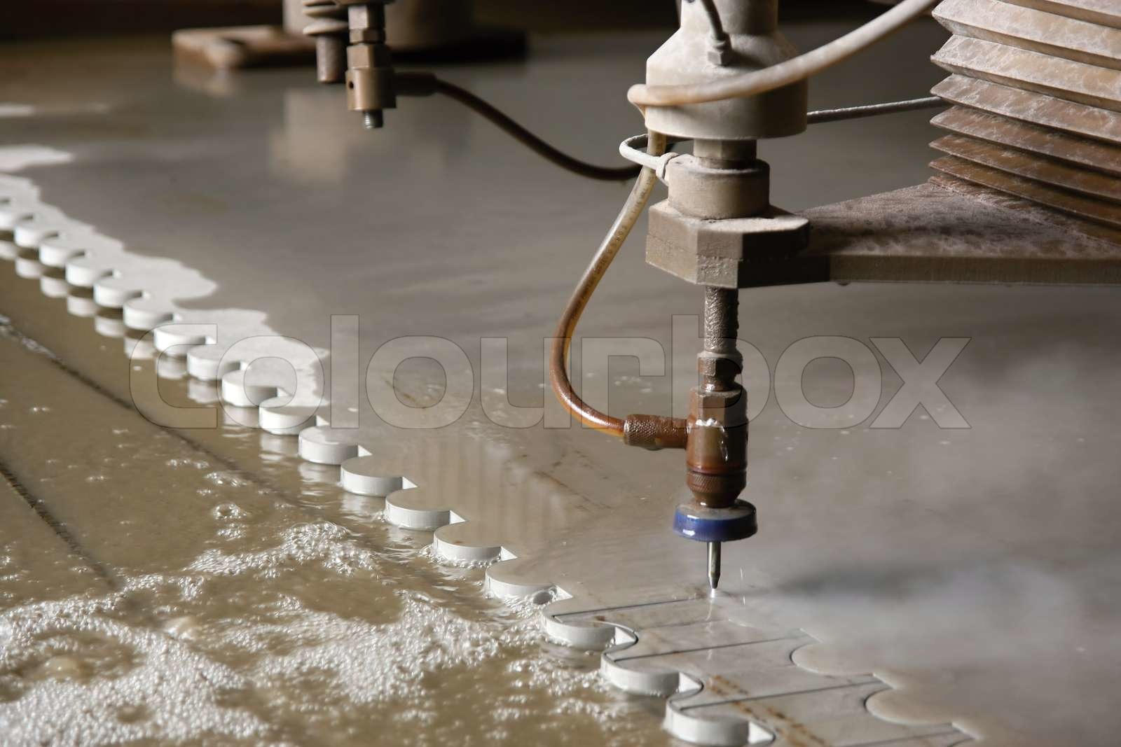 Machine using water pressure to cut through stainless steel materials ...