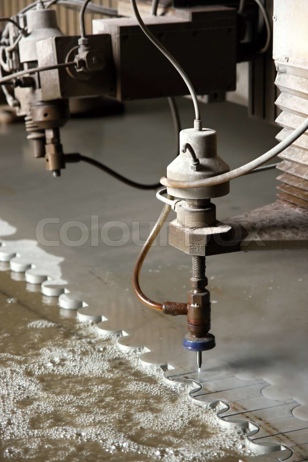 Machine using water pressure to cut through stainless steel materials ...