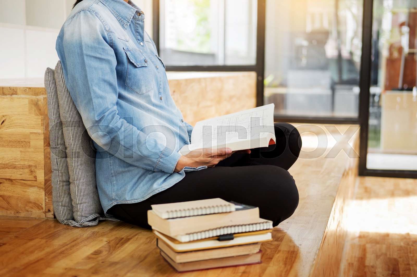 Thoughtful female student sitting Serious reading a book in a library ...