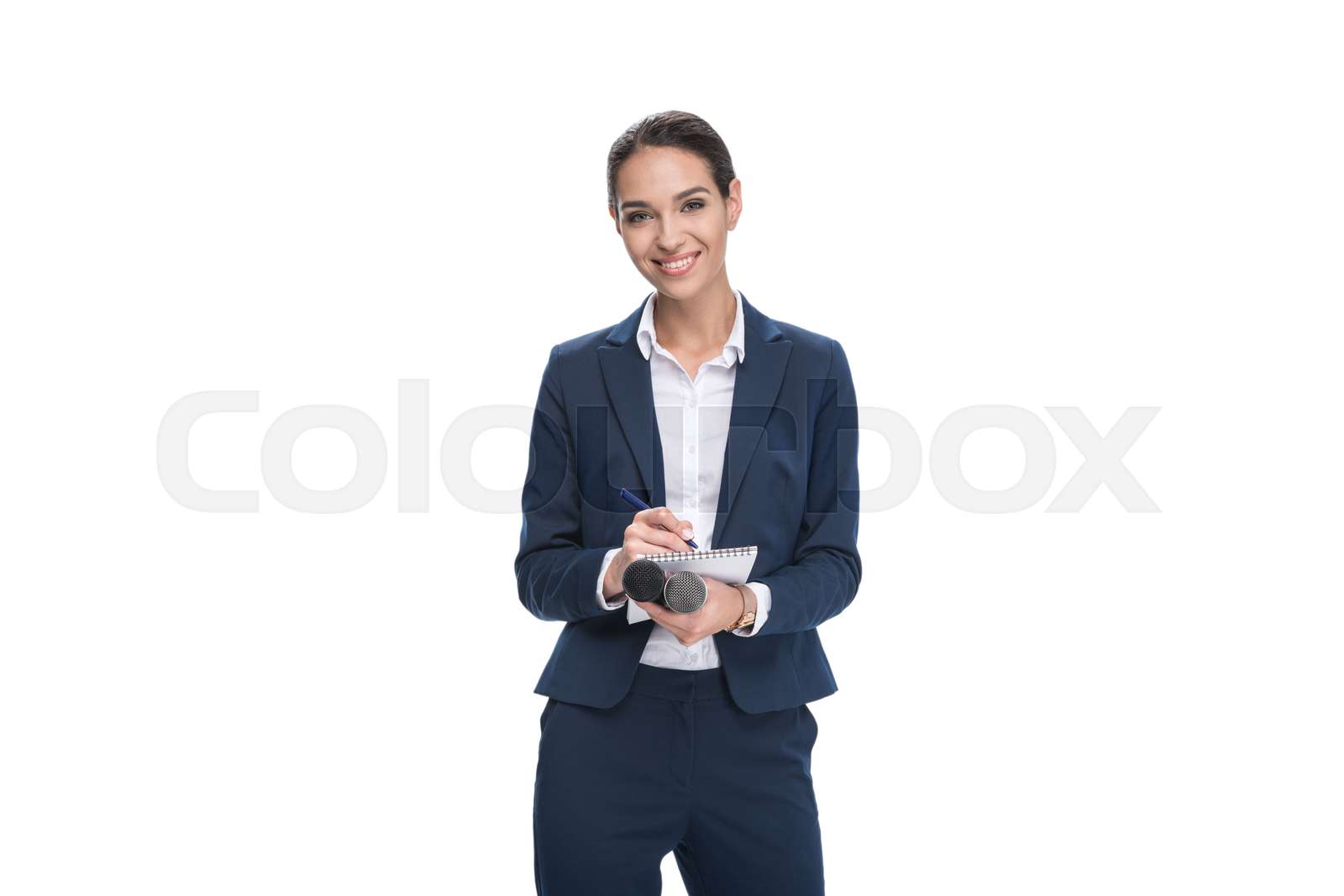smiling female journalist in suit with microphone writing in notepad ...