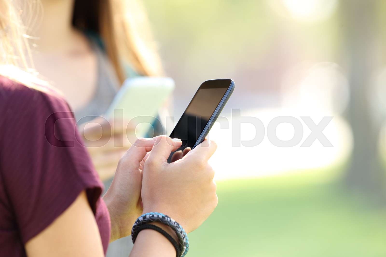 Teen hands using smart phones | Stock image | Colourbox