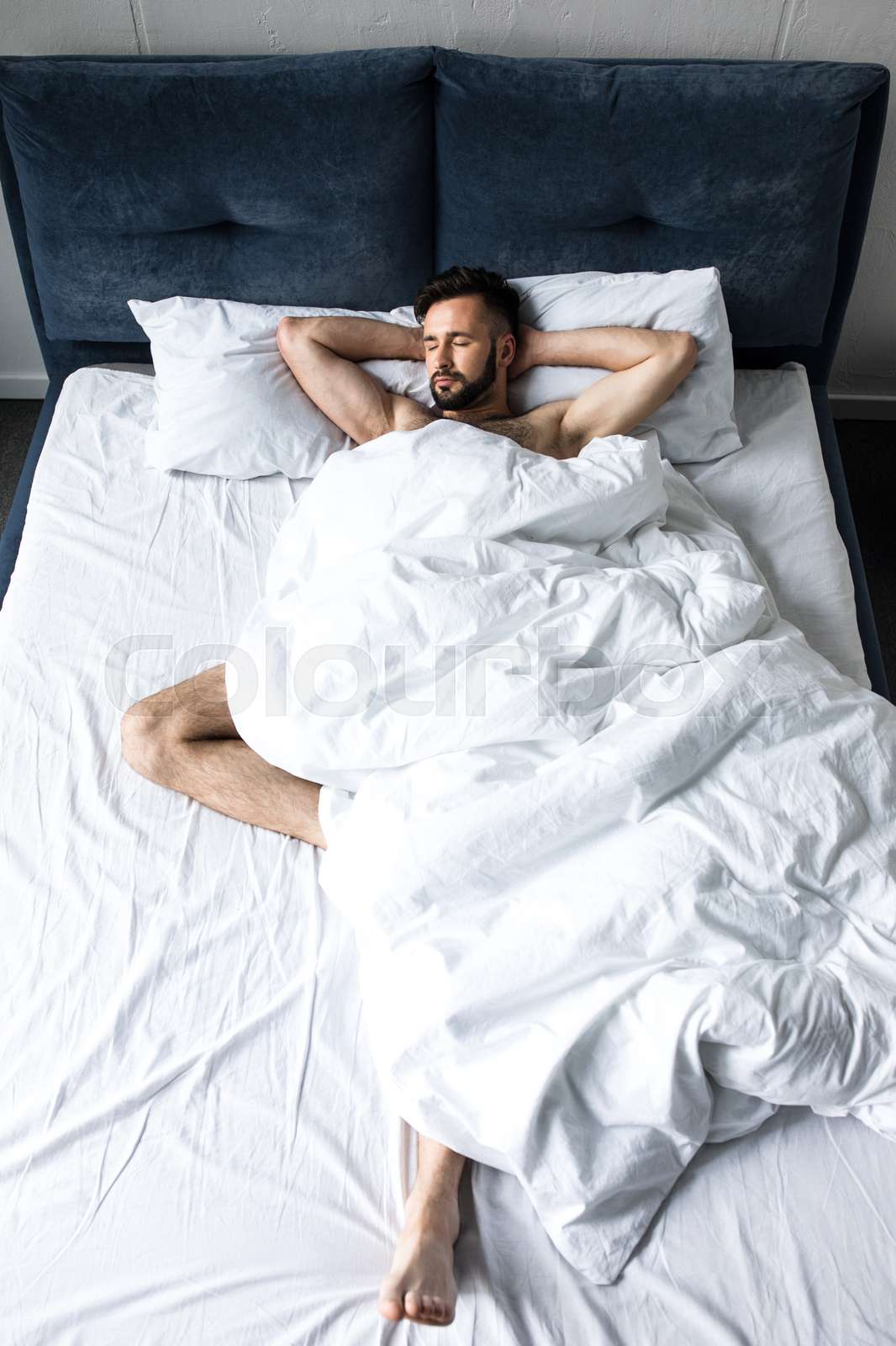 Handsome Shirtless Bearded Man Sleeping In Bed Under White Blanket In
