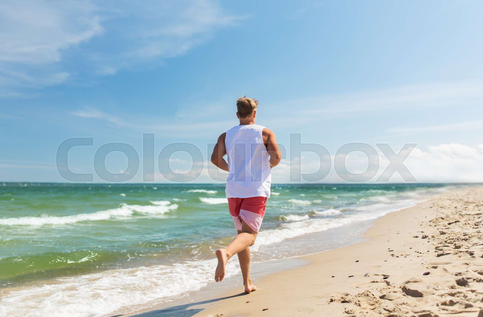 happy man running along summer beach | Stock image | Colourbox
