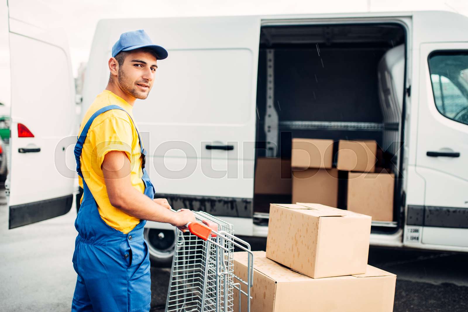 Male courier in uniform work with cargo, back view | Stock image ...