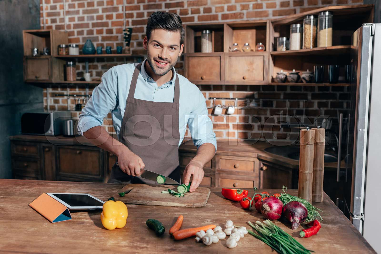 handsome young man cutting vegetables | Stock image | Colourbox