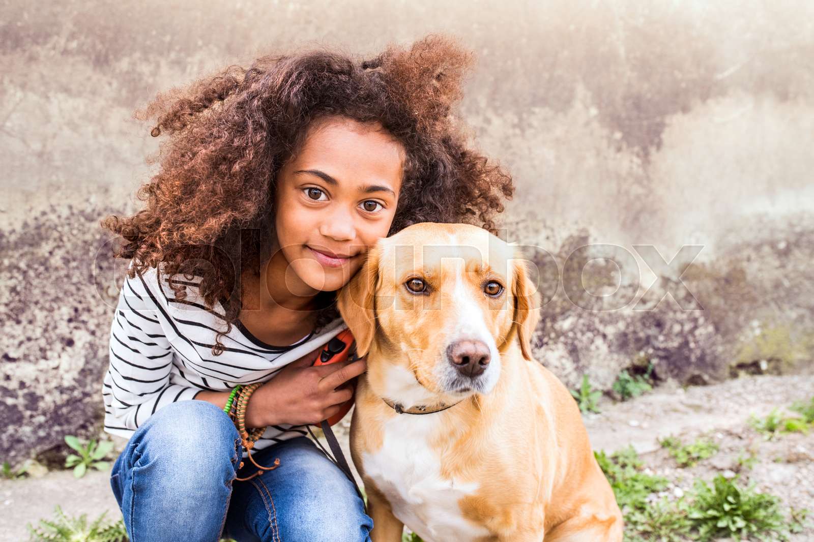 African american girl with her dog against concrete wall. | Stock image ...