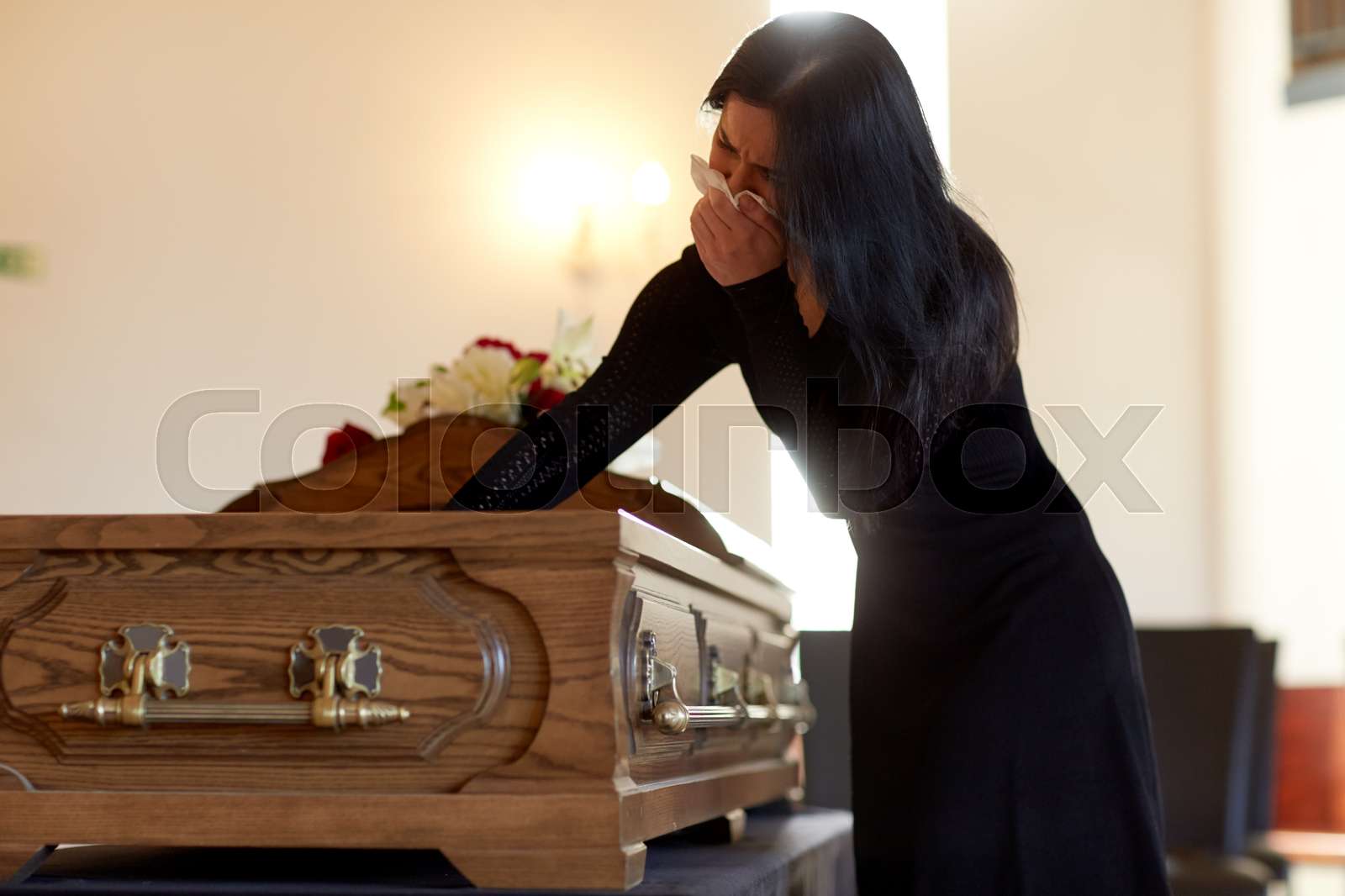 woman with coffin crying at funeral in church | Stock image | Colourbox