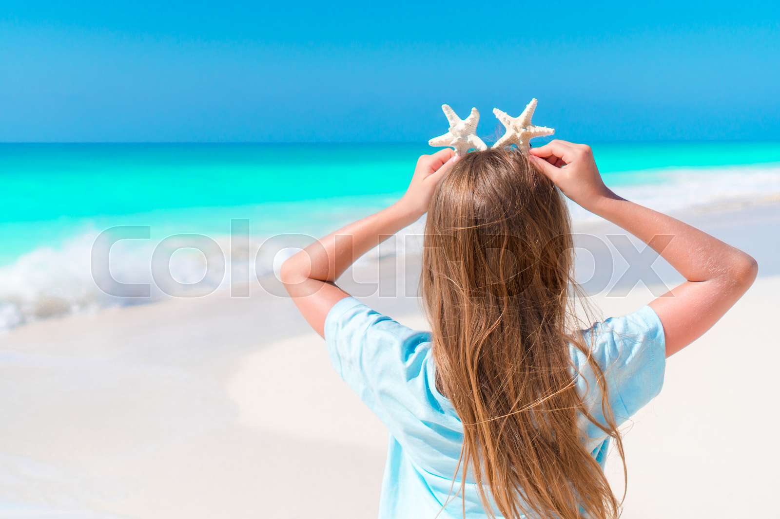 Back view of little girl having fun on white sandy beach | Stock image ...
