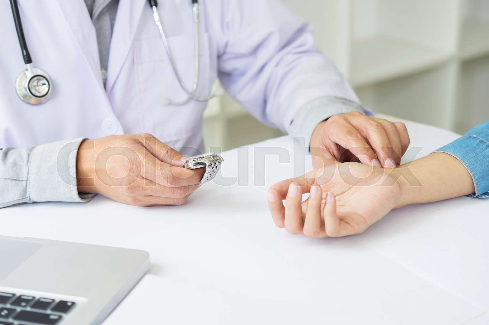 doctor checking patient heart rate pulse | Stock image | Colourbox