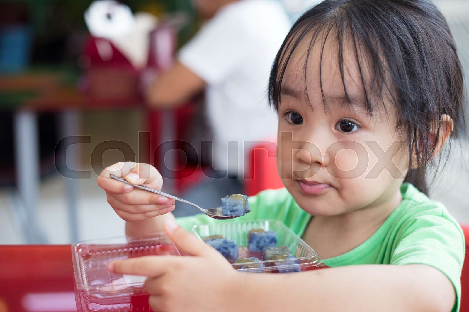 Asian little Chinese girl eating glutinous rice | Stock image | Colourbox