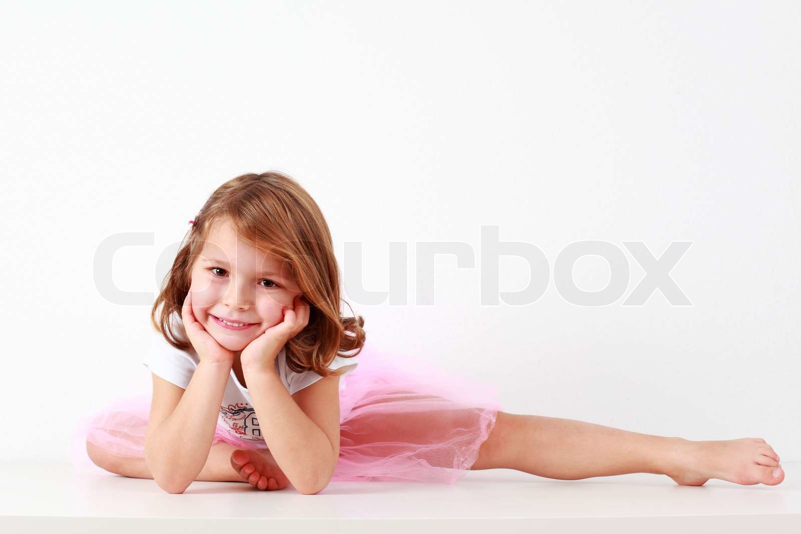 Cute little girl making splits on white background | Stock image ...