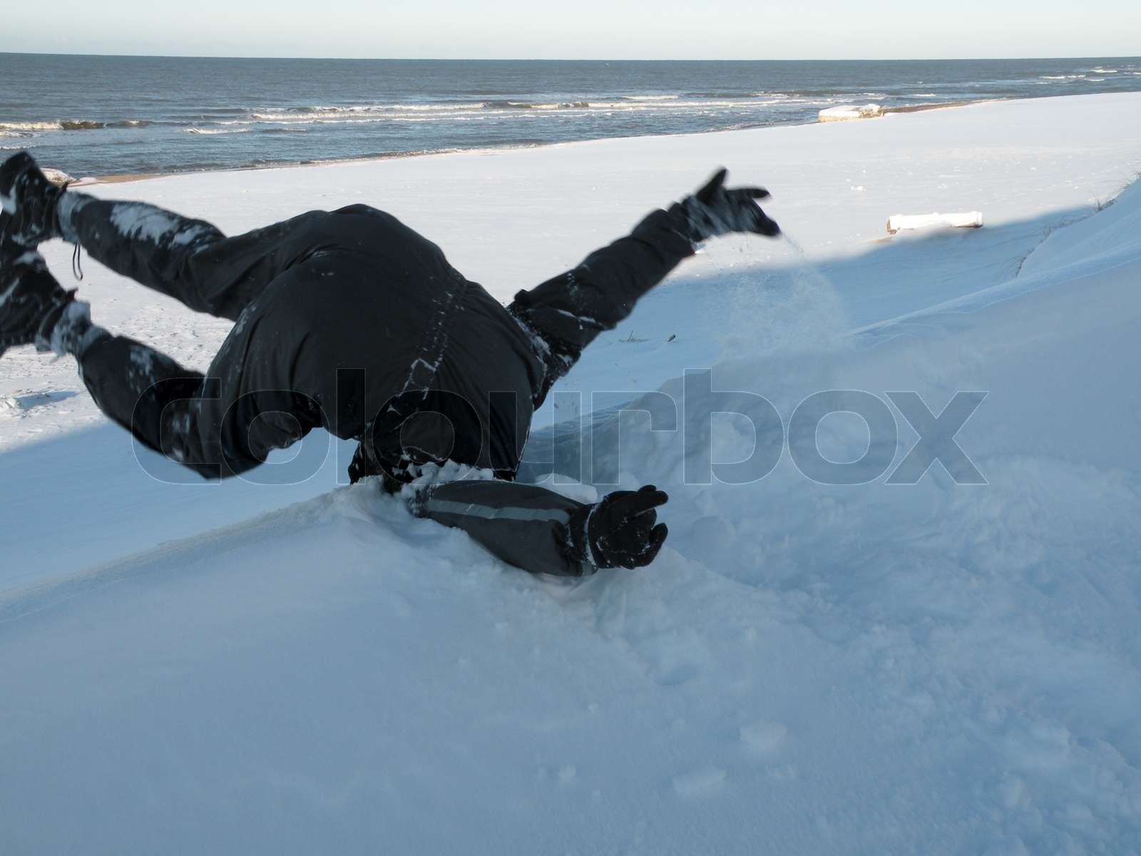 mand falder ned en sne omfattet klit på nordsøen | Stock foto | Colourbox