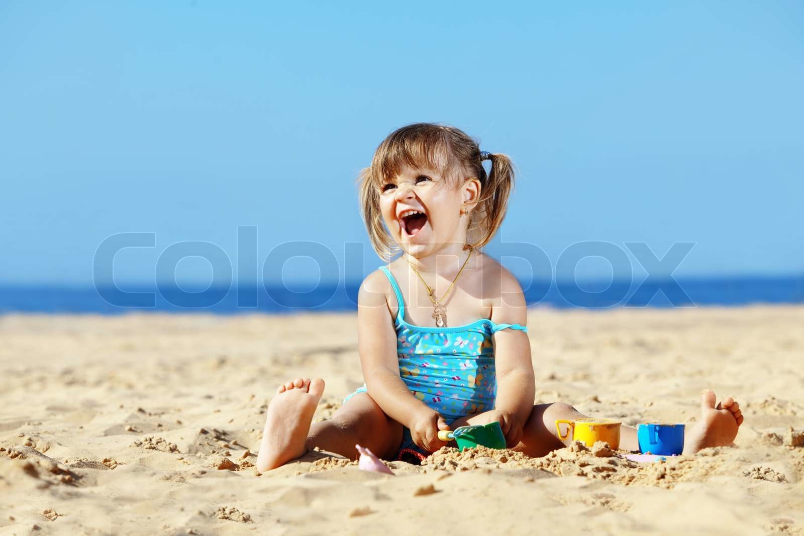 Happy child playing with sand at the beach in summer | Stock image ...