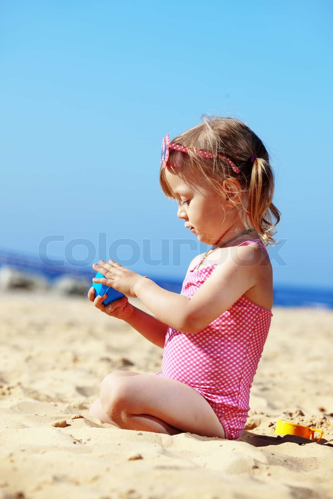 Glückliches Kind spielt mit Sand am Strand im Sommer | Stock Bild ...